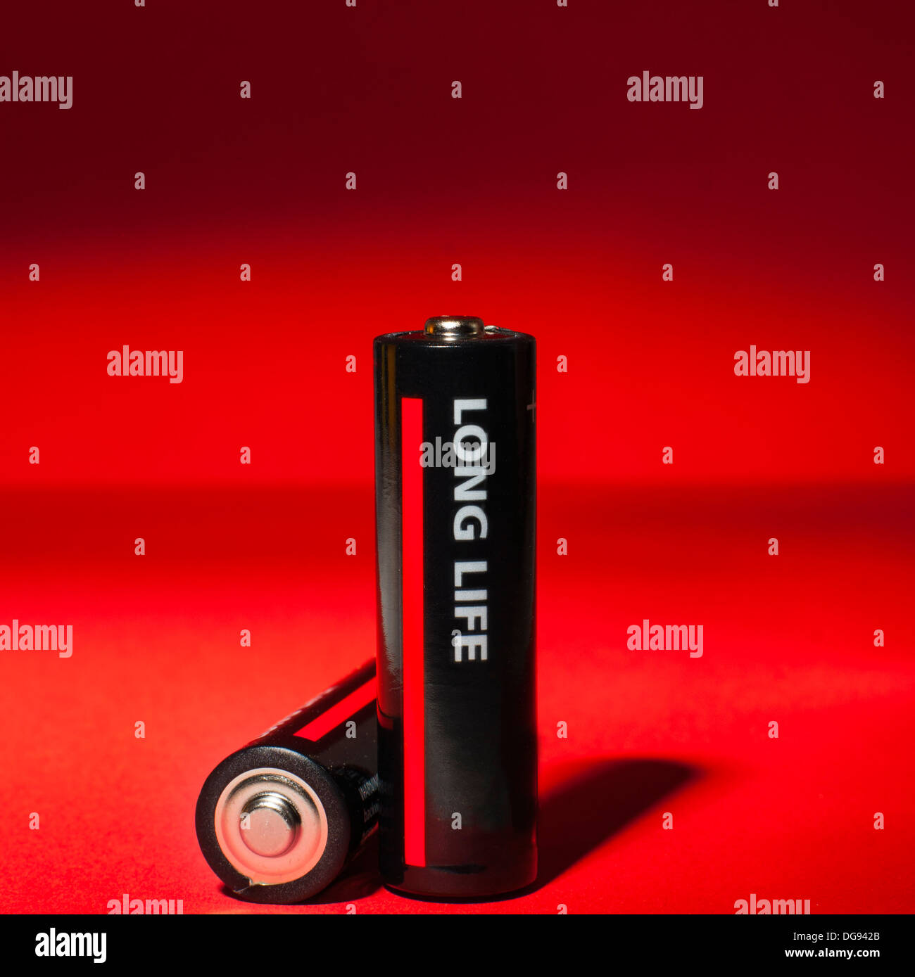Batteries on a red background Stock Photo - Alamy