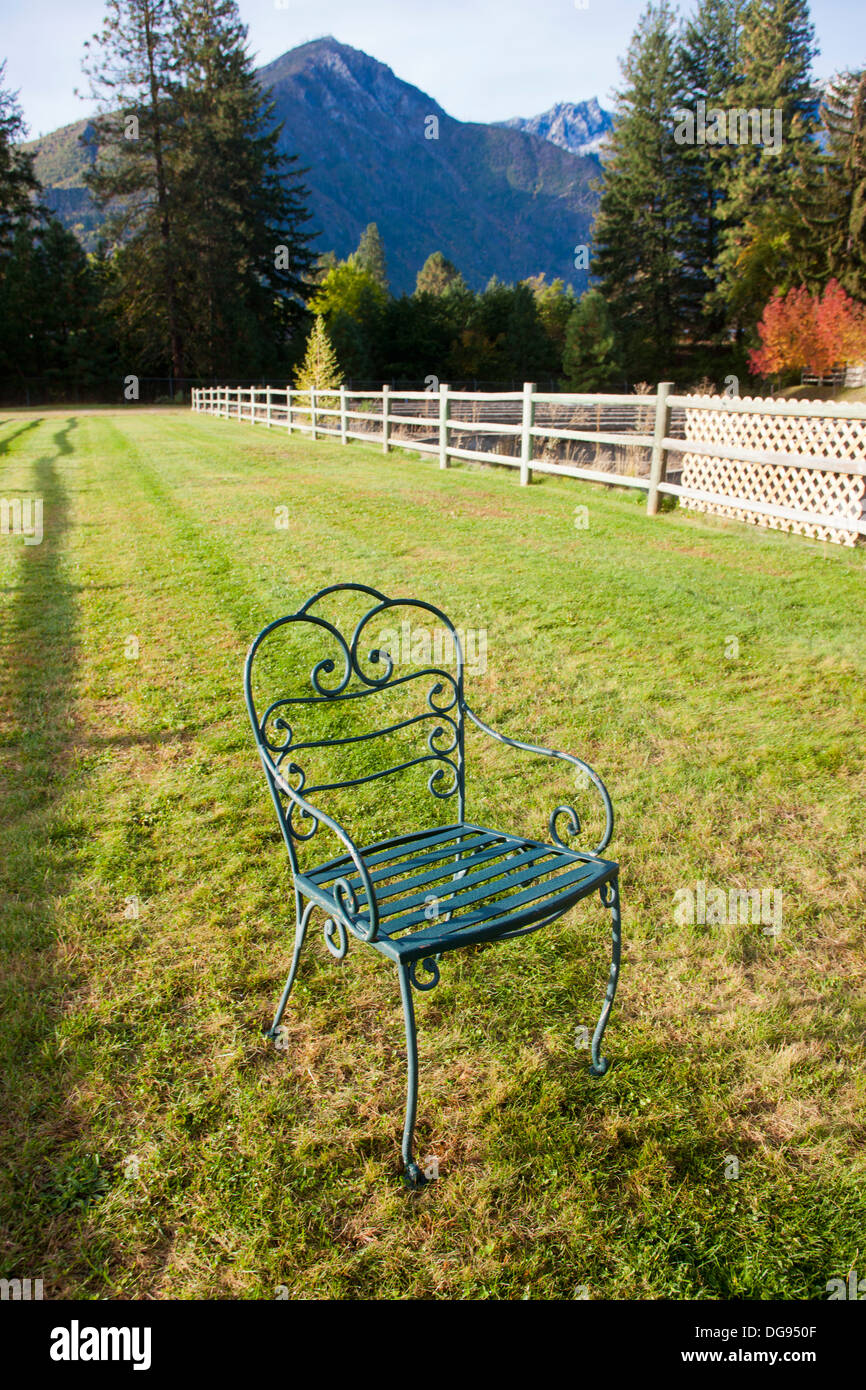 Iron chair by fence Stock Photo - Alamy