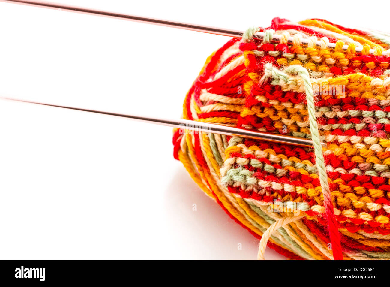 Knitting with multi colored yarn with orange, red, and yellow tones ...