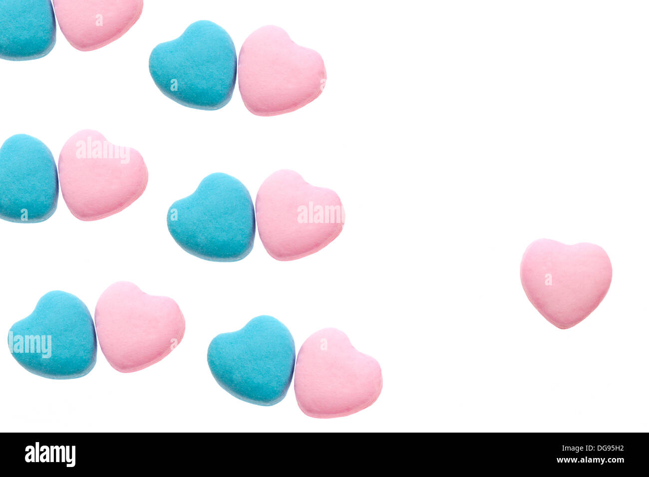 candy hearts arranges in "couples" and a lonely pink heart on a white ...