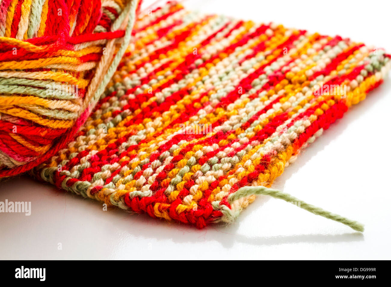 Knitting with multi colored yarn with orange, red, and yellow tones ...