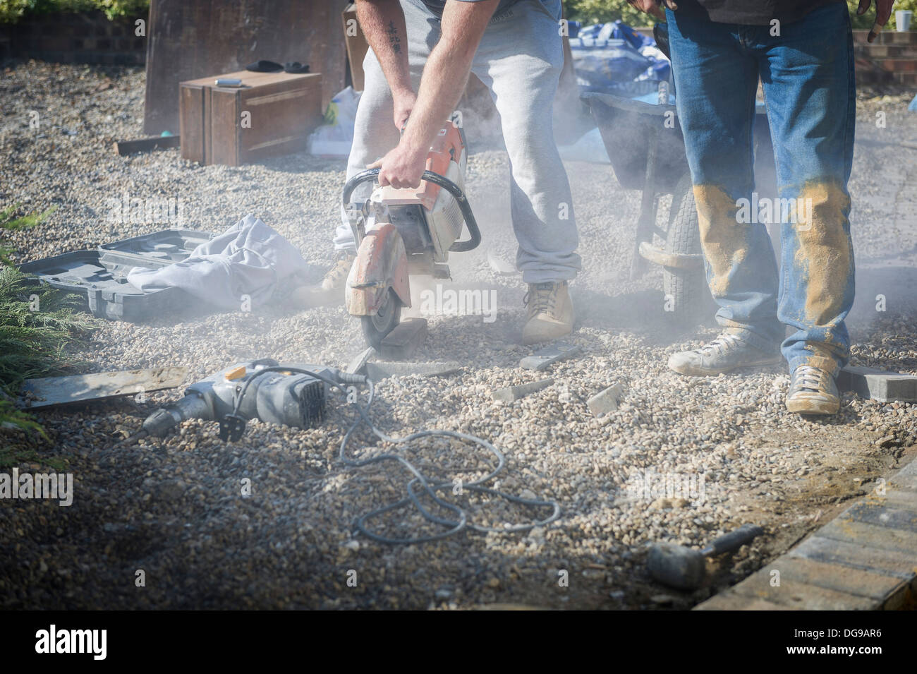 A worker using a disc cutter to cut a paving block Stock Photo - Alamy