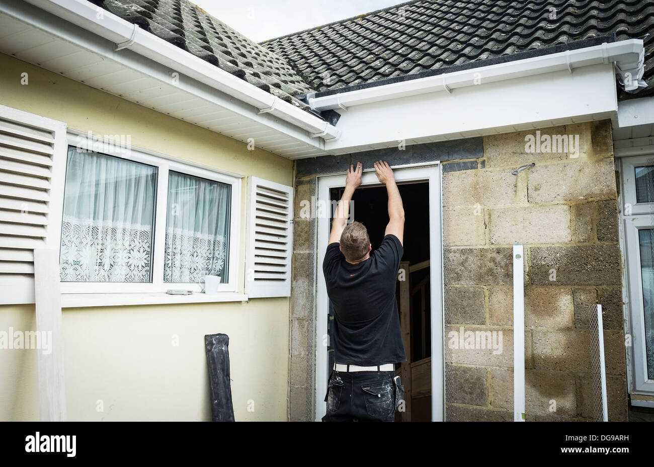 A workman fixing Render Stop Beading above a doorway Stock Photo - Alamy