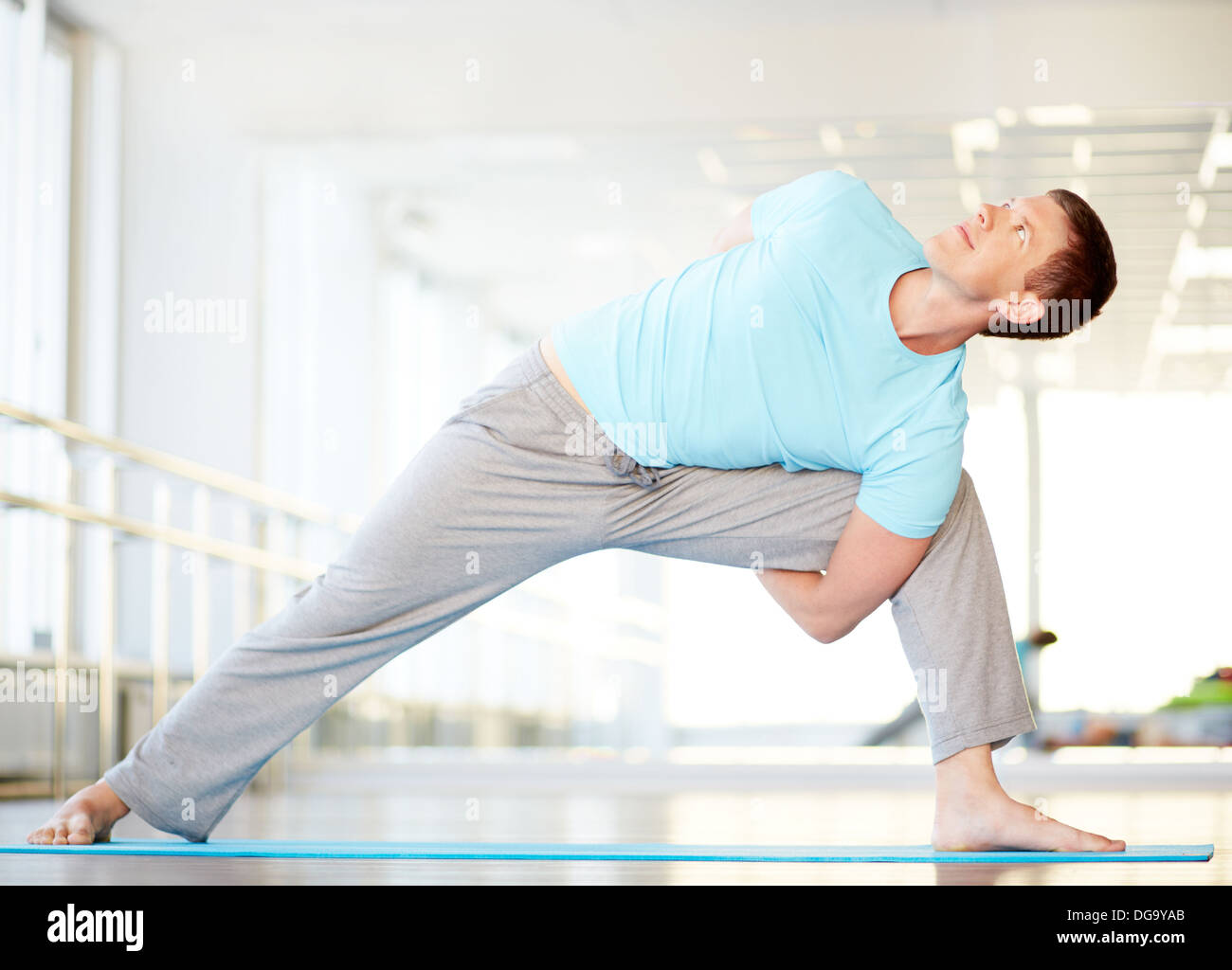 Portrait of young man doing stretching exercise in gym Stock Photo - Alamy