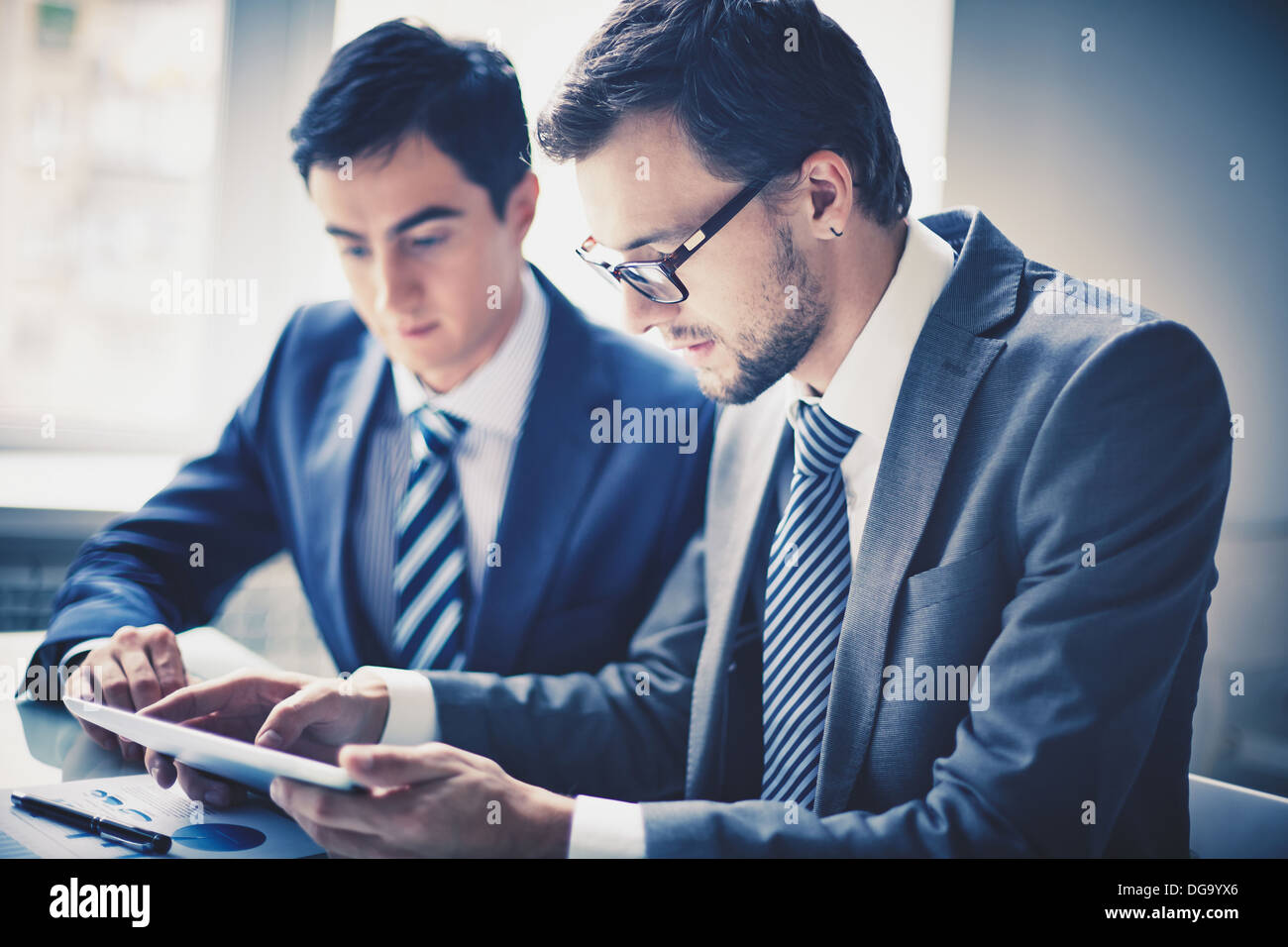 Image of two young businessmen using touchpad Stock Photo - Alamy