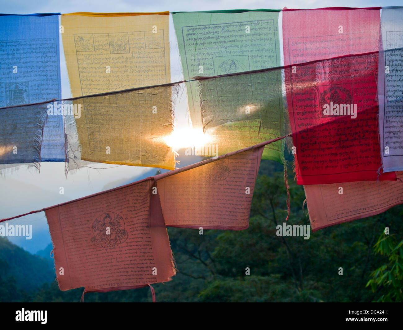 Setting sun shining through colorful prayer flags with the himalayan ...