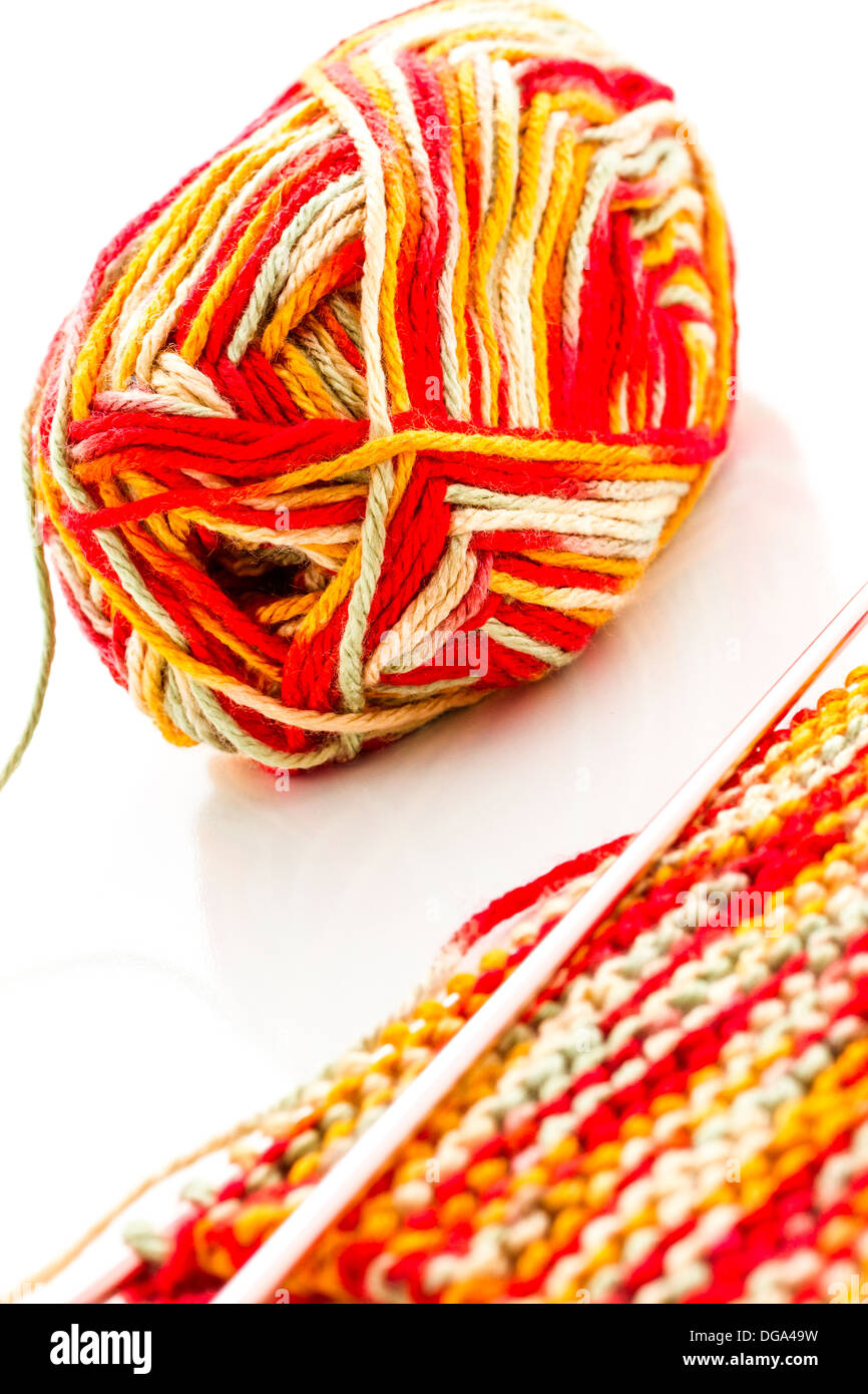 Knitting with multi colored yarn with orange, red, and yellow tones ...