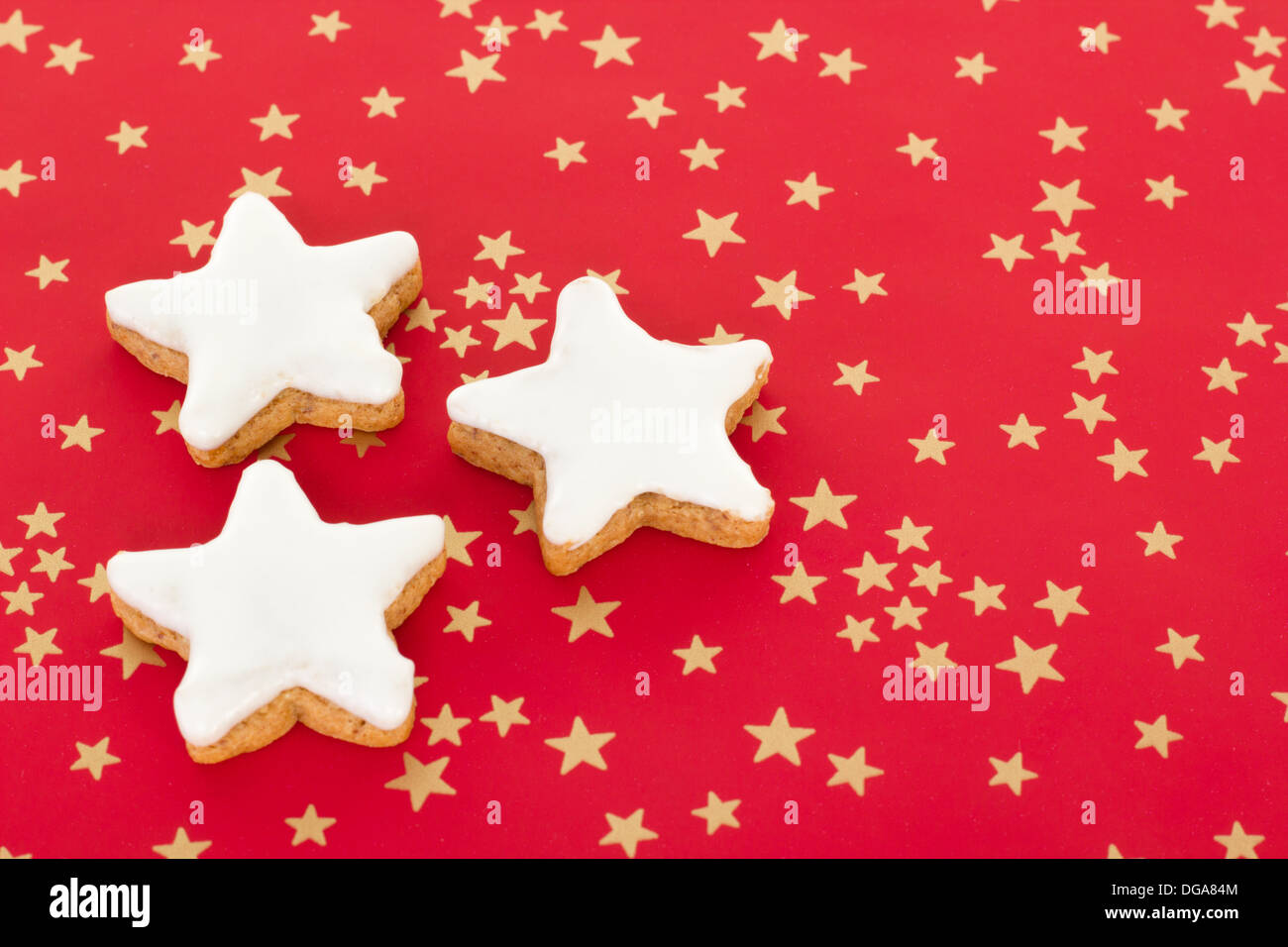 Star shaped cinnamon biscuits on red background with golden stars Stock ...