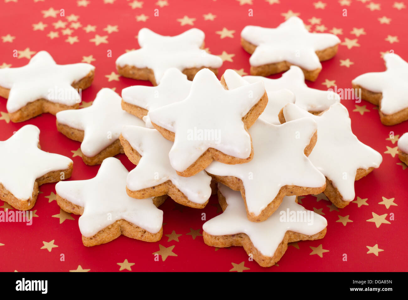 Star shaped cinnamon biscuits on red background with golden stars Stock ...