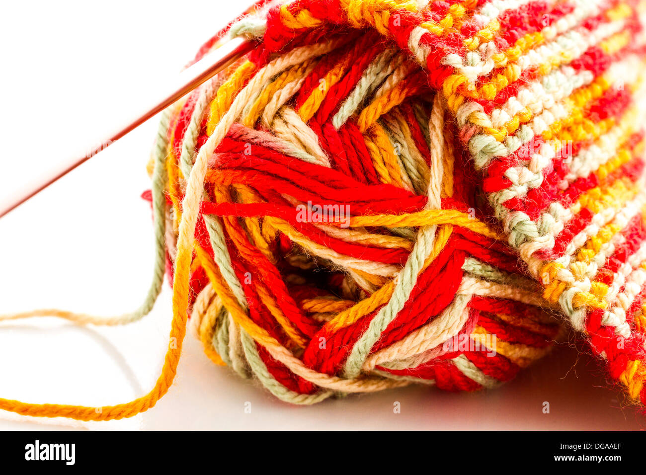 Knitting with multi colored yarn with orange, red, and yellow tones ...