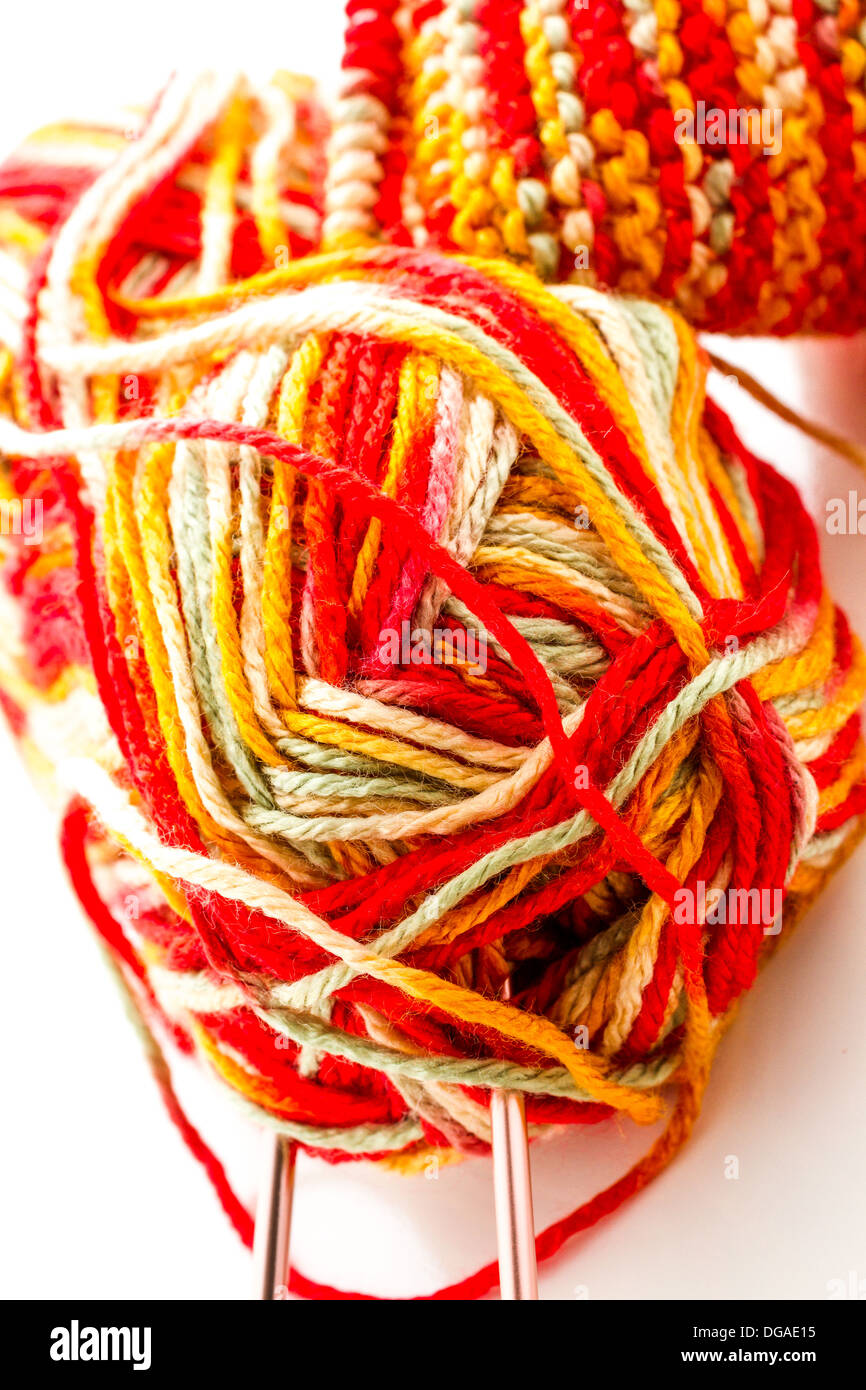 Knitting with multi colored yarn with orange, red, and yellow tones ...
