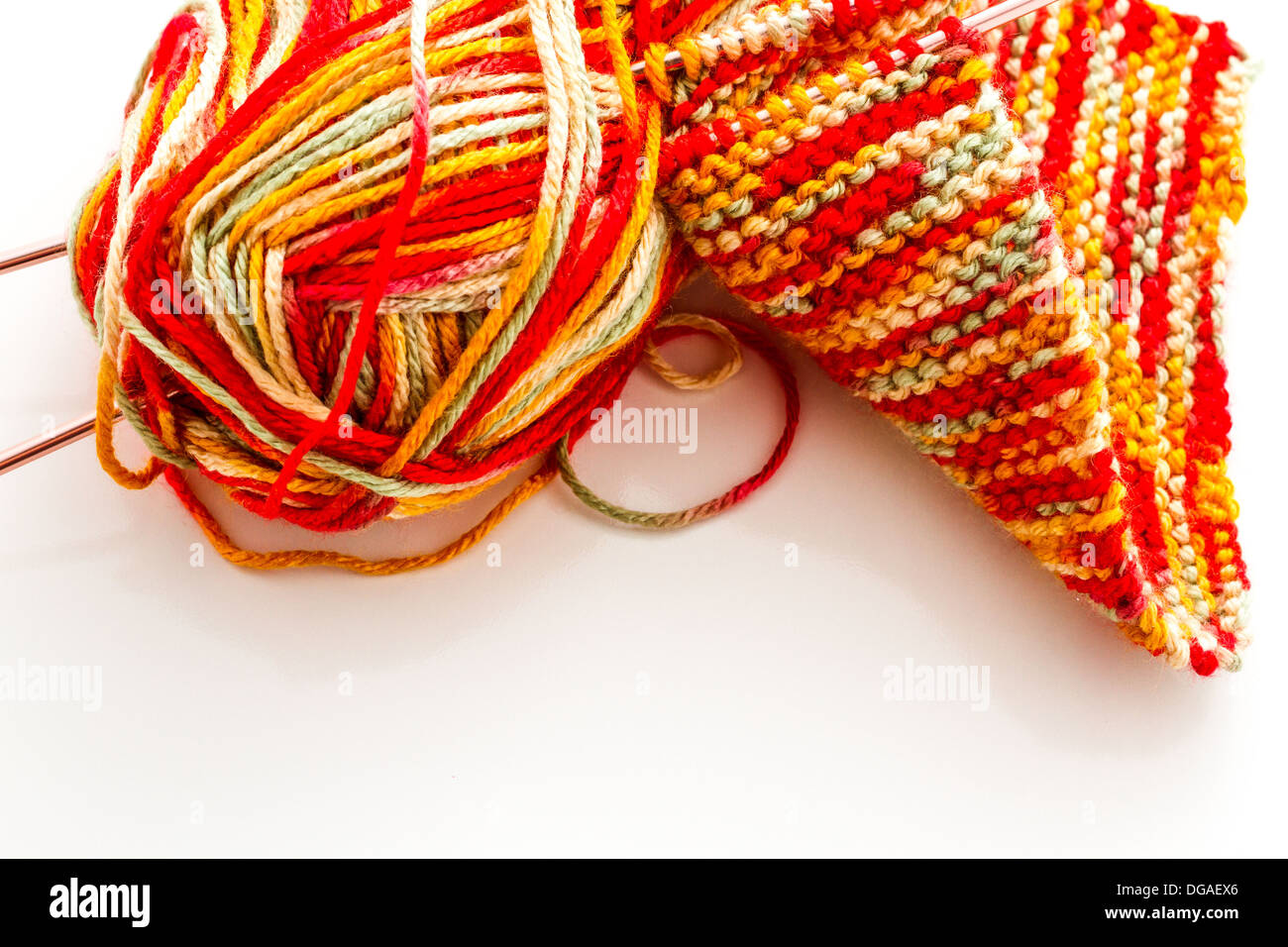 Knitting with multi colored yarn with orange, red, and yellow tones ...