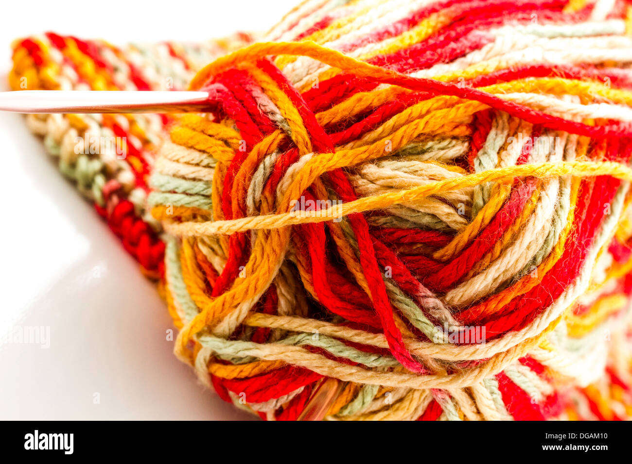 Knitting with multi colored yarn with orange, red, and yellow tones ...