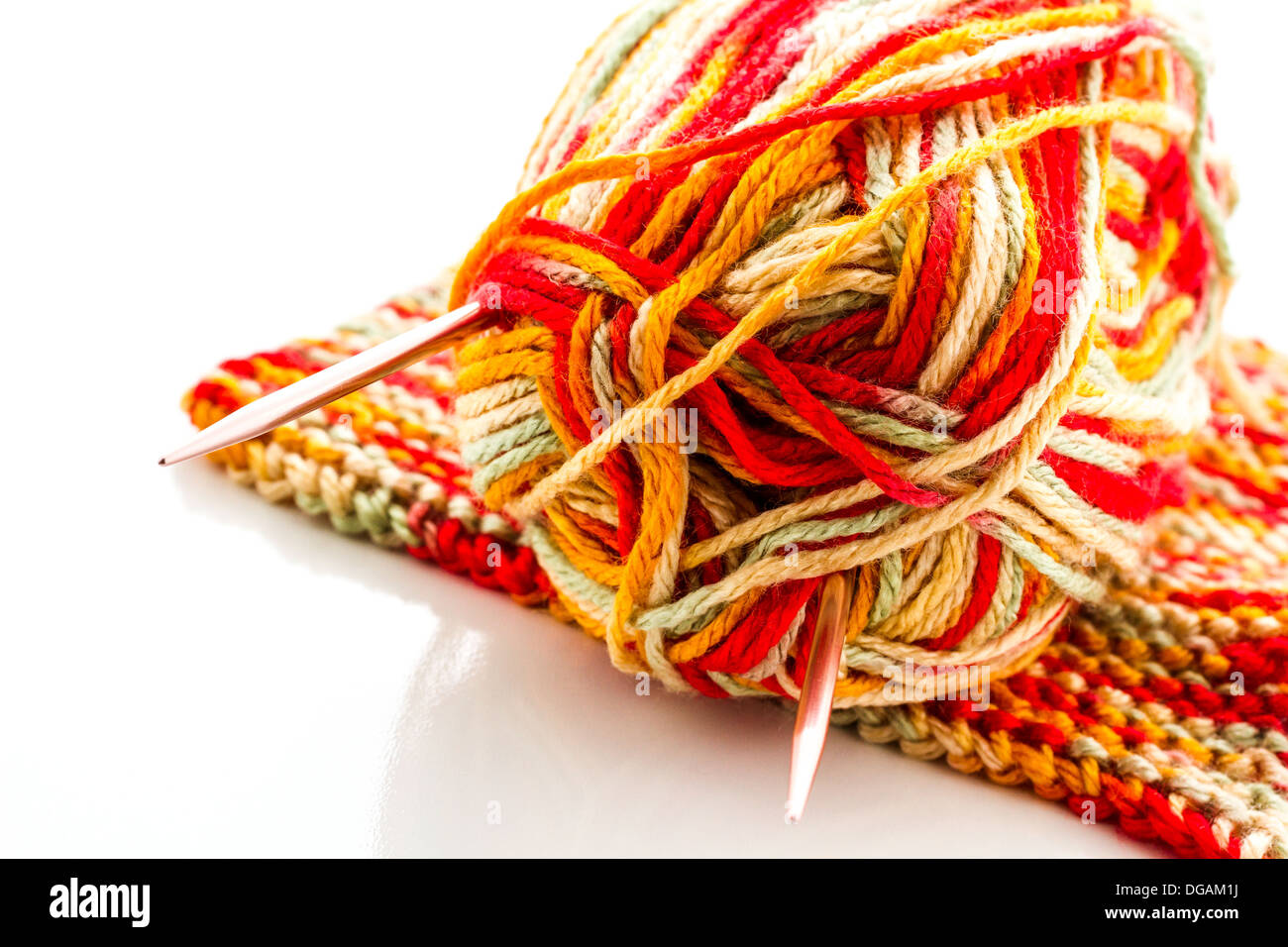 Knitting with multi colored yarn with orange, red, and yellow tones ...