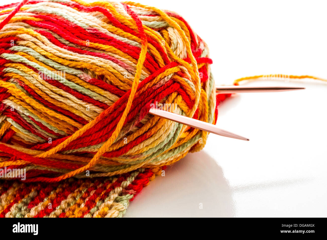 Knitting with multi colored yarn with orange, red, and yellow tones ...