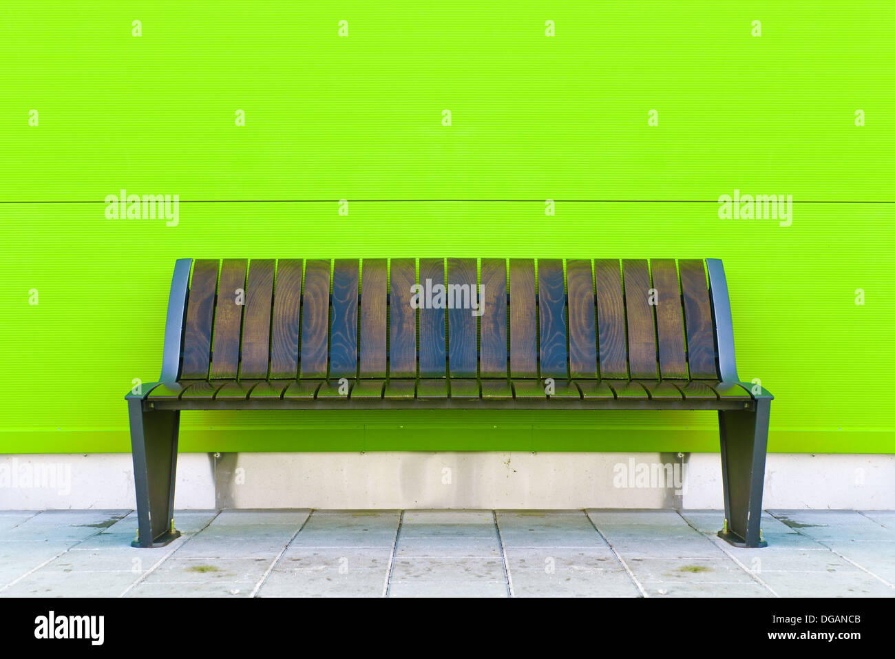 Stylish bench against green wall as background Stock Photo - Alamy