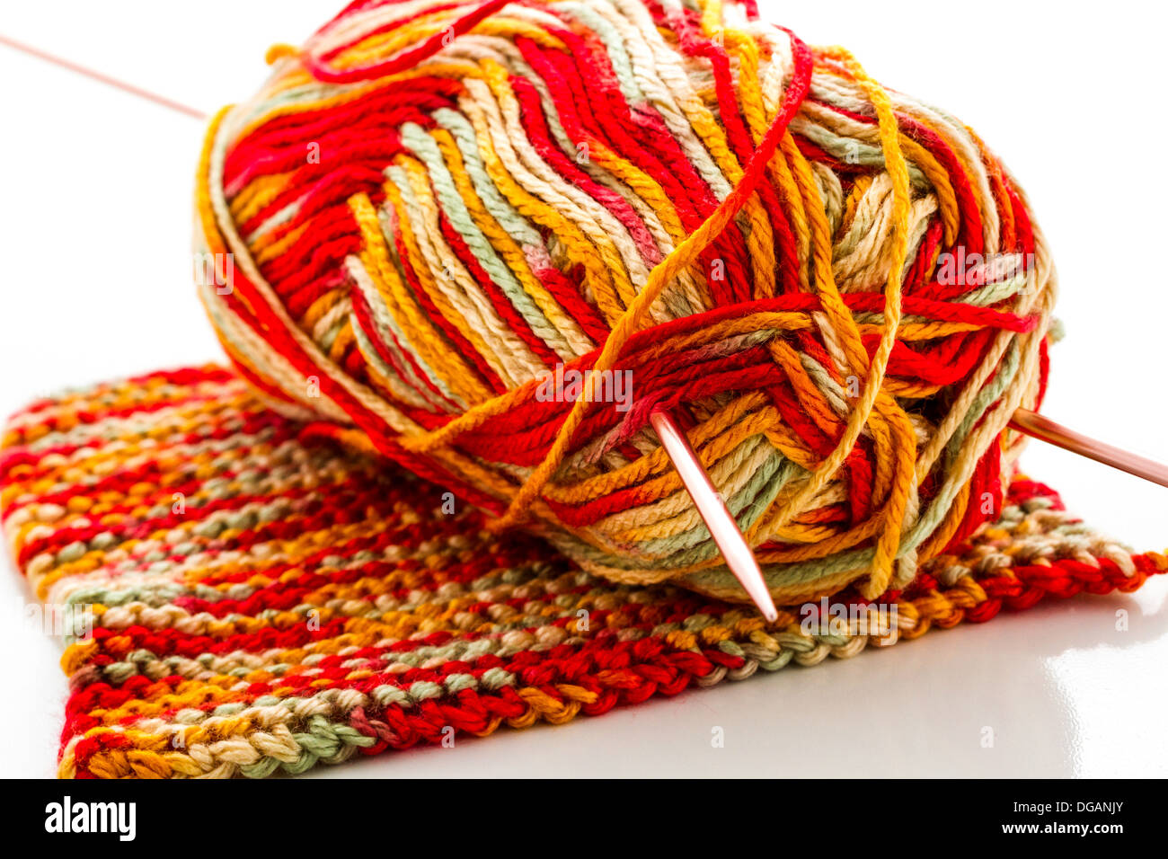 Knitting with multi colored yarn with orange, red, and yellow tones ...