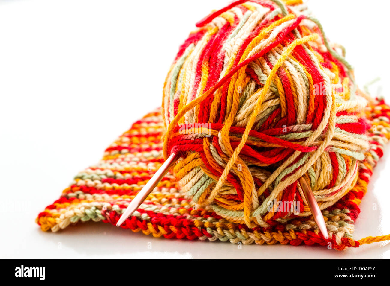 Knitting with multi colored yarn with orange, red, and yellow tones ...