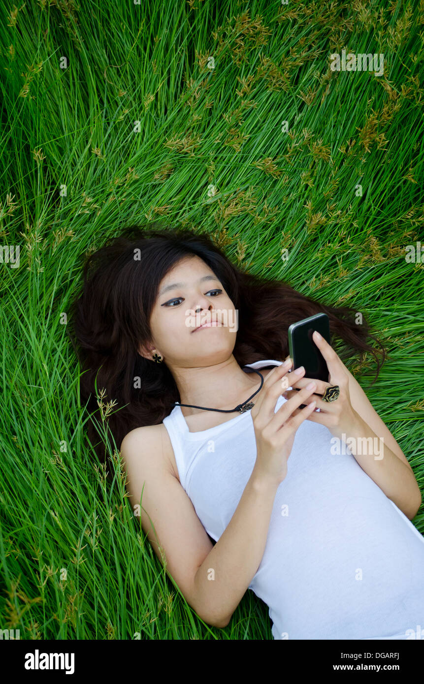asian cute girl texting on meadow with happy face Stock Photo - Alamy