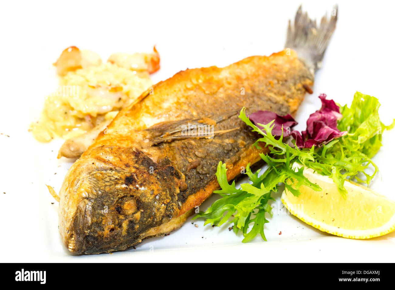 Fried fish dorado with vegetables and lemon Stock Photo - Alamy