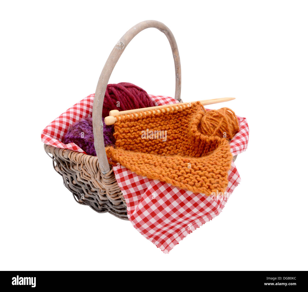Purple, red and orange yarn with knitting in a basket, isolated on a ...