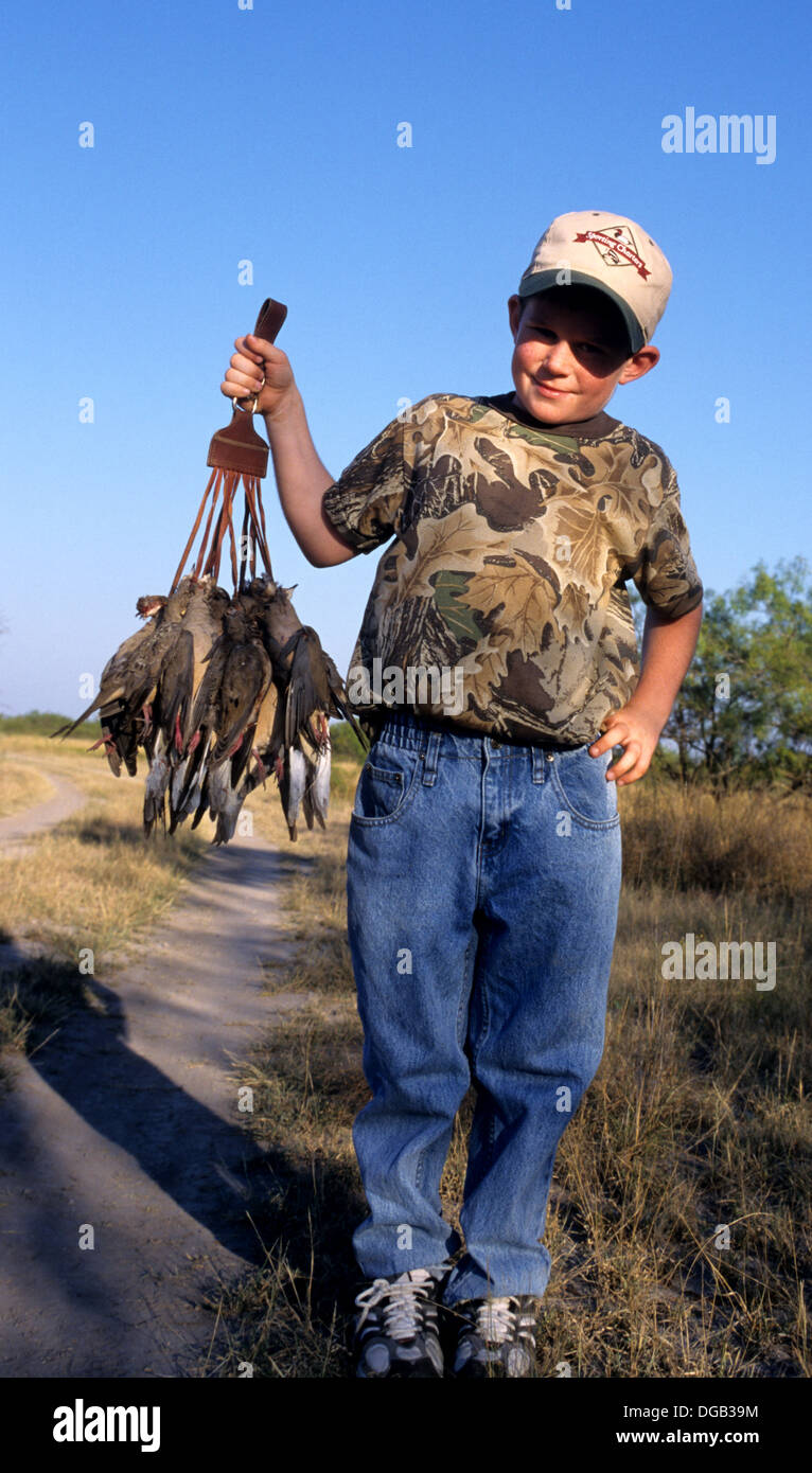 A young boy with mourning doves (Zenaida macroura) while dove hunting ...