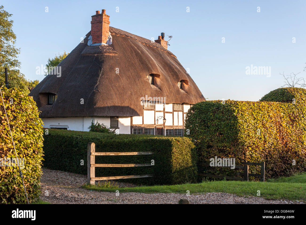Traditional thatched cottage on rural road in English countryside ...