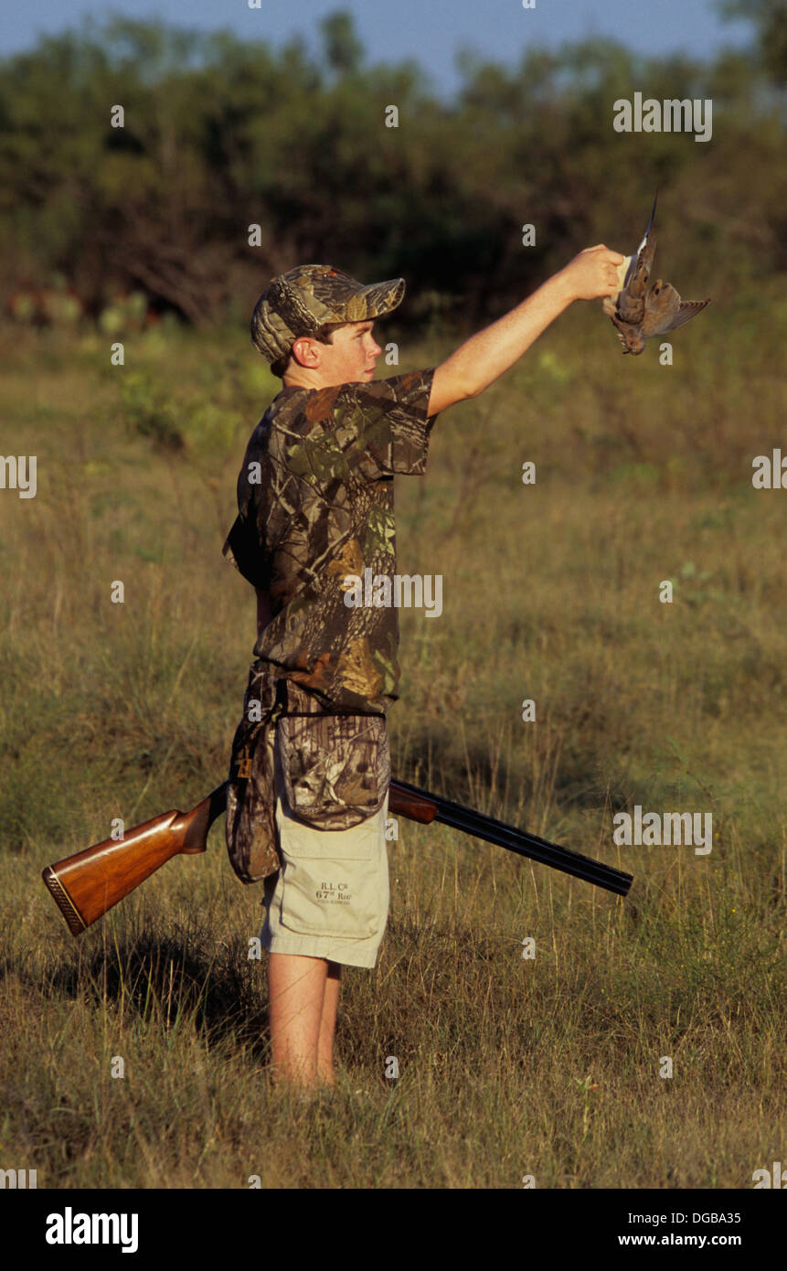 A young boy with a mourning dove (Zenaida macroura) while hunting doves ...
