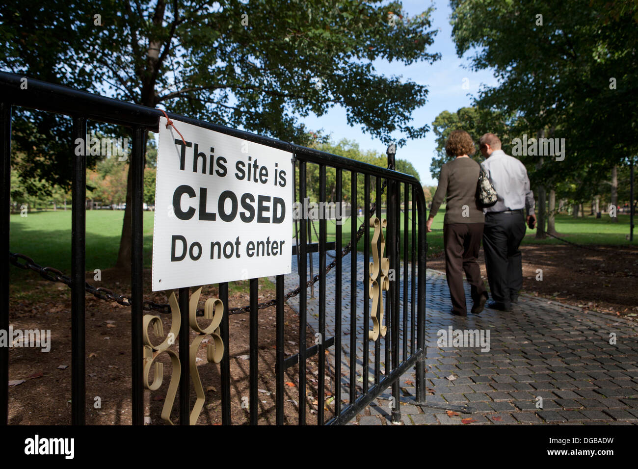 Couple walking passed site closed sign - USA Stock Photo - Alamy