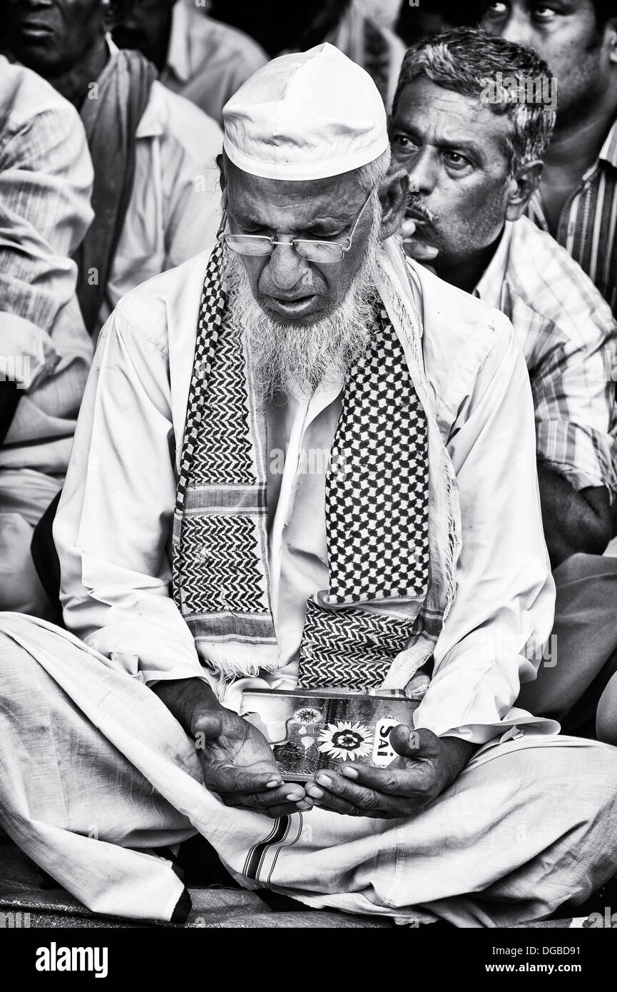 Indian Muslim man in prayer whilst waiting to be seen at Sri Sathya Sai ...