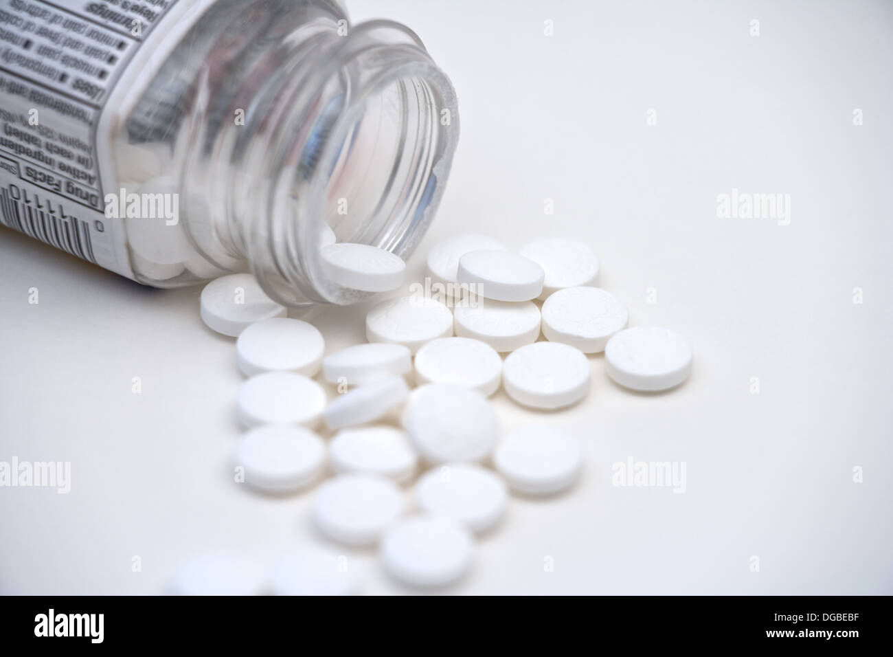 Aspirin pills pouring out of a pill bottle on a white background Stock ...
