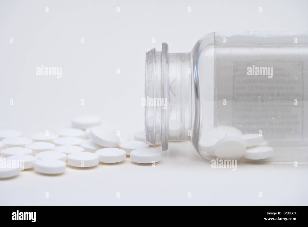 Aspirin pills pouring out of a pill bottle on a white background Stock ...