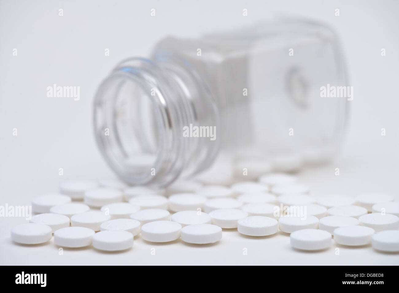 Aspirin pills pouring out of a pill bottle on a white background Stock ...
