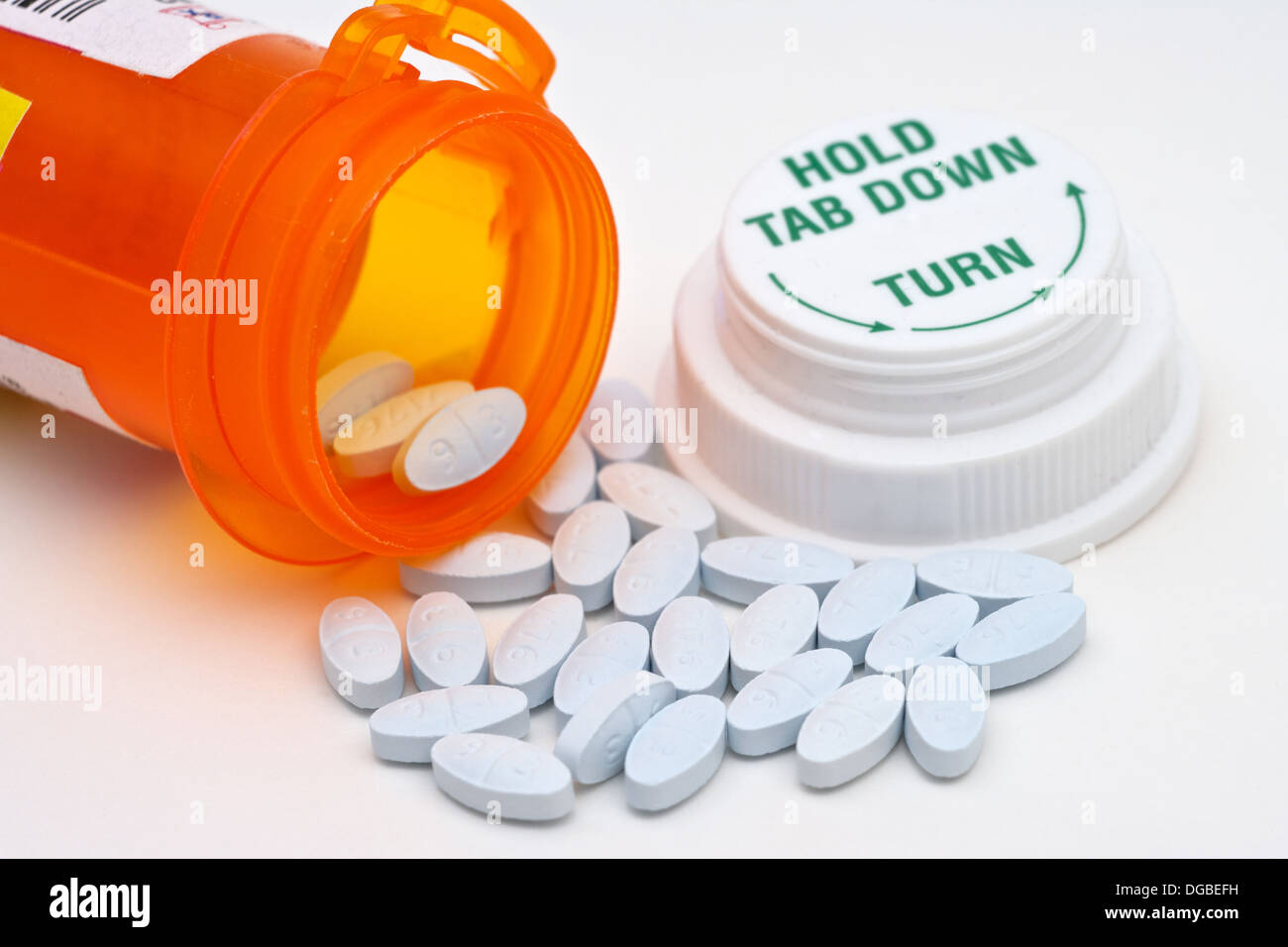 Pills and overturned pill bottles spilled out on a white background ...