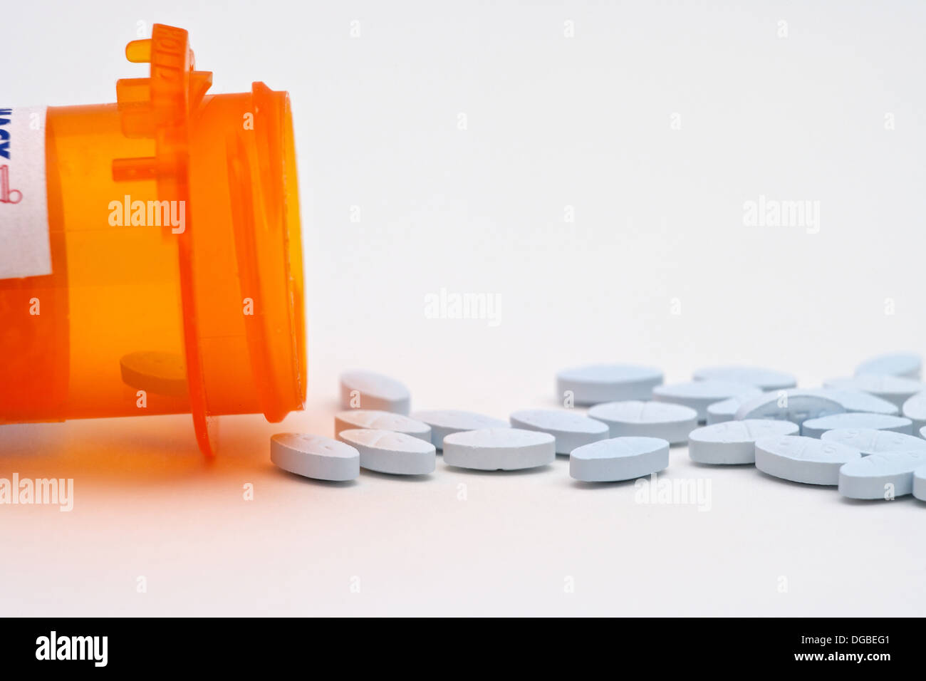 Pills and overturned pill bottles spilled out on a white background ...