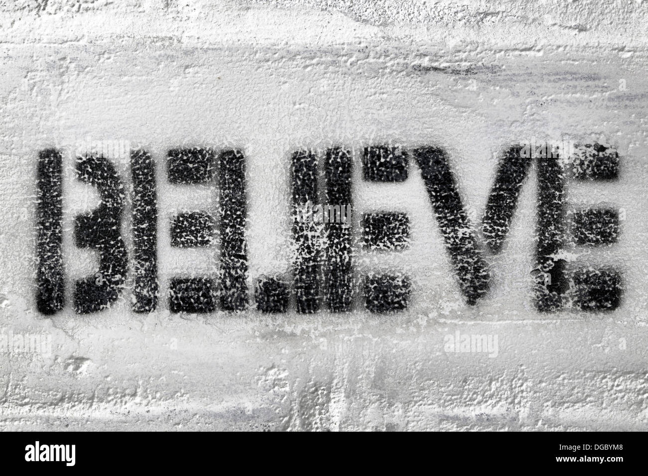 textured black stencil print of believe word on the weathered white ...