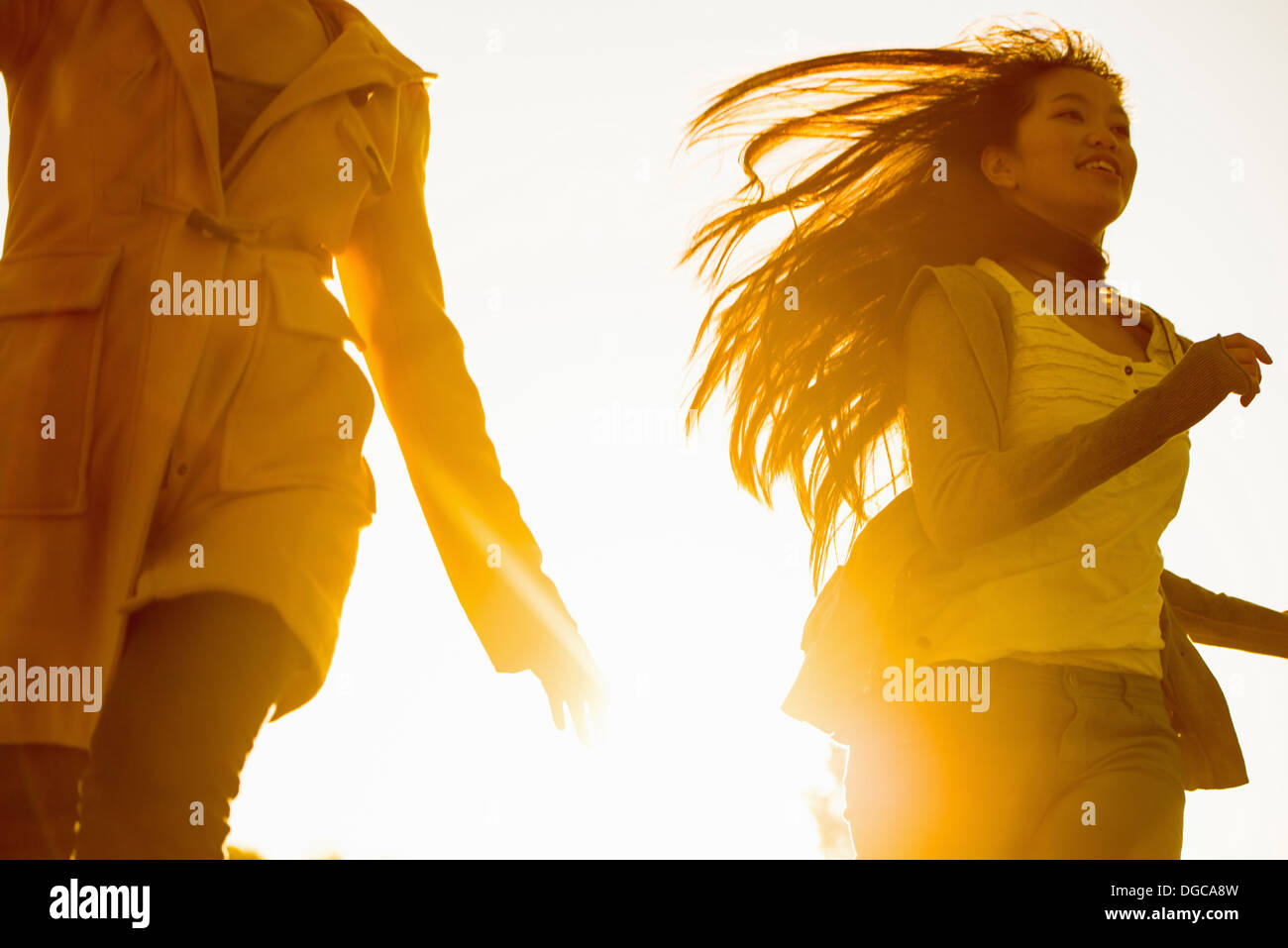 Two young female friends running in park Stock Photo - Alamy