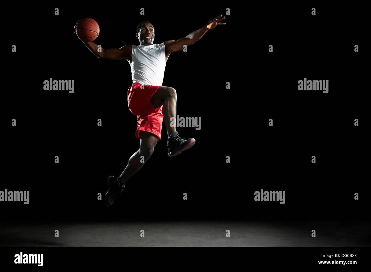 Young male basketball player jumping with ball Stock Photo - Alamy
