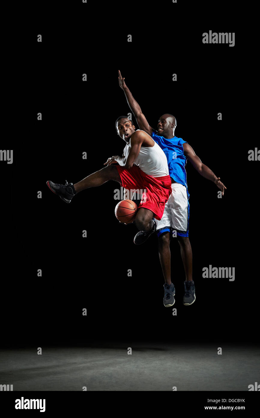 Male basketball players jumping and shooting ball Stock Photo - Alamy