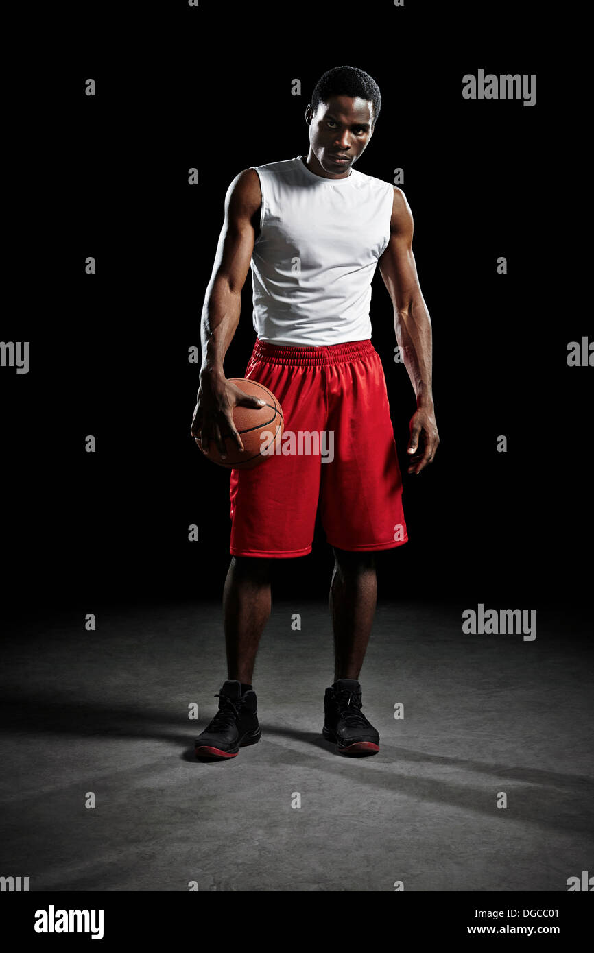 Studio shot of basketball player holding ball Stock Photo - Alamy