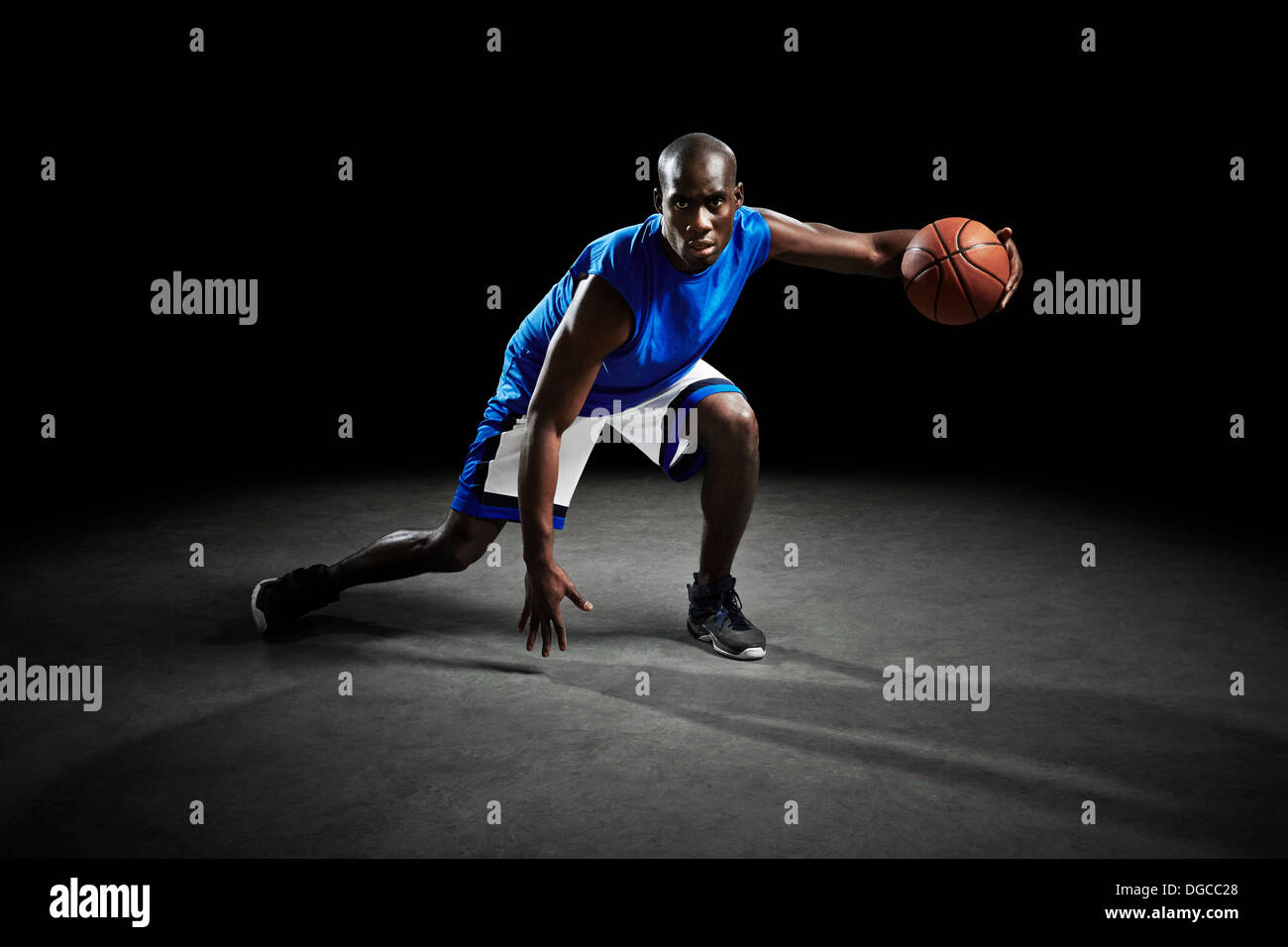 Studio shot of basketball player holding ball Stock Photo - Alamy