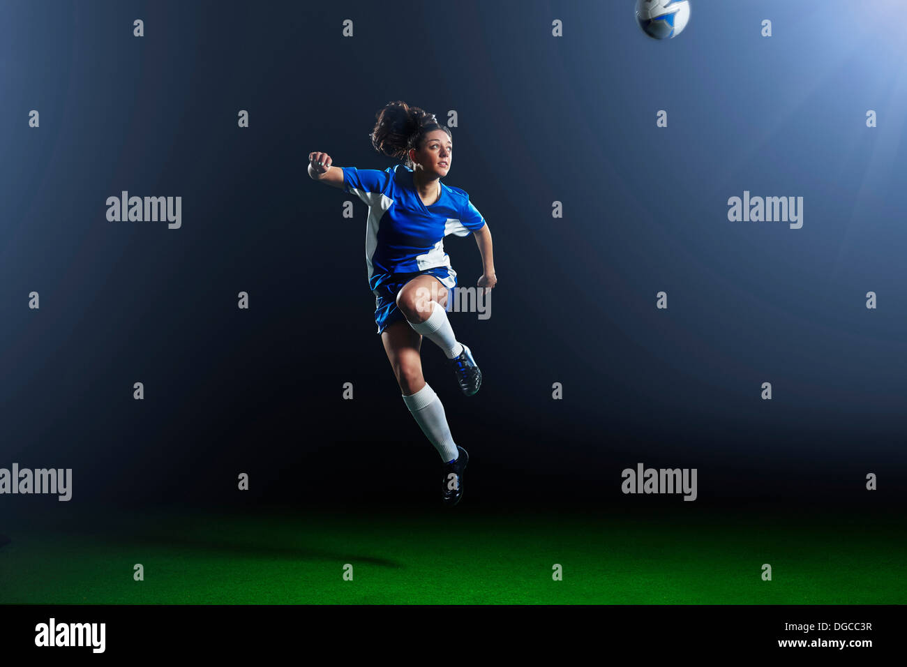 Young female soccer player mid air Stock Photo - Alamy