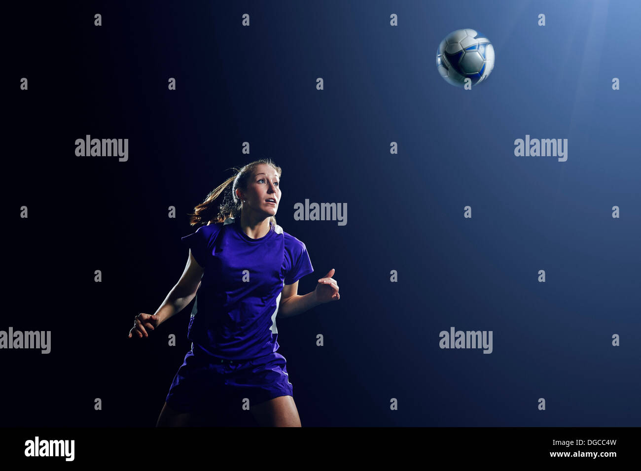 Young female soccer player heading ball Stock Photo - Alamy
