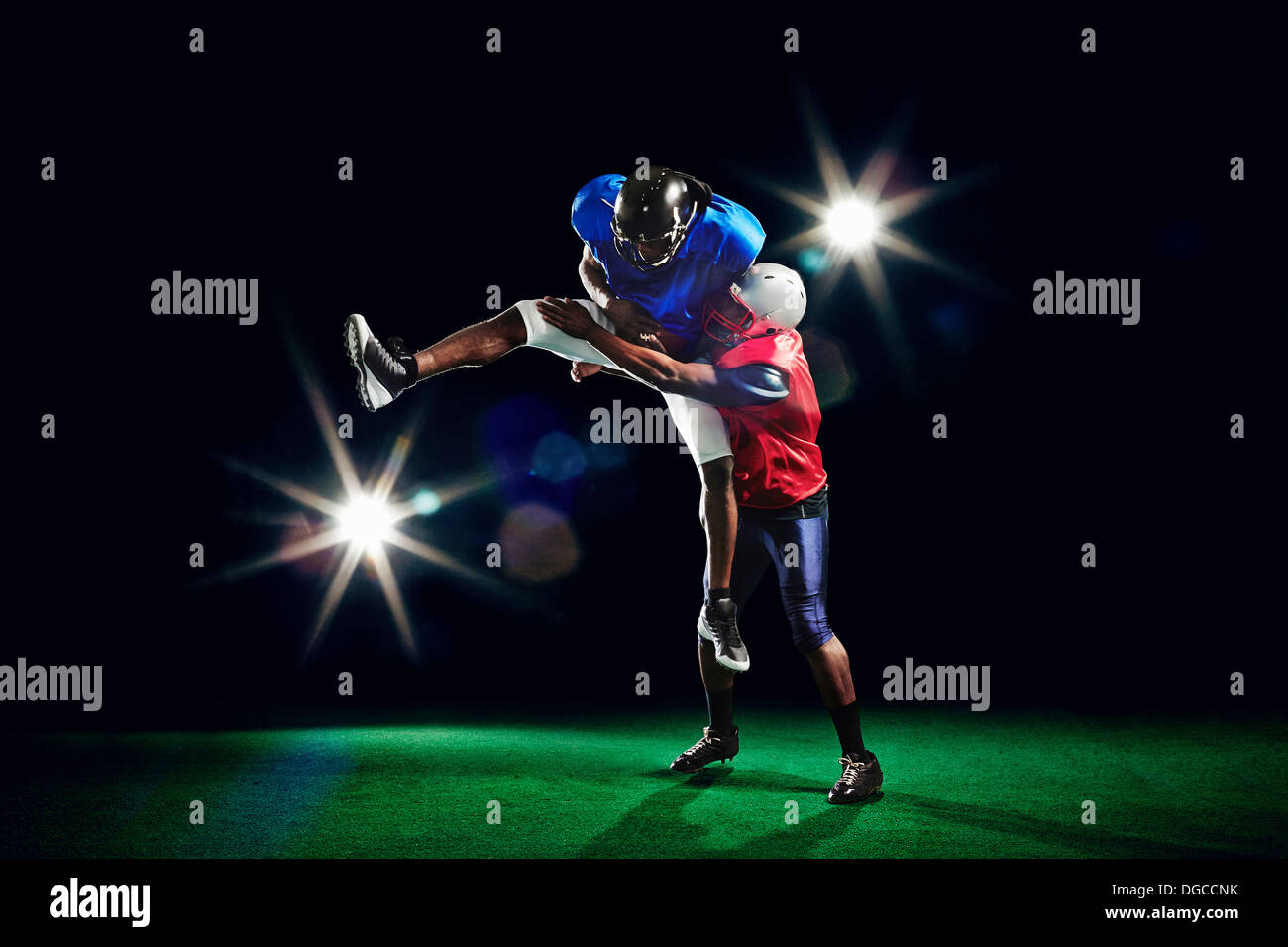 American football players jumping with ball Stock Photo - Alamy