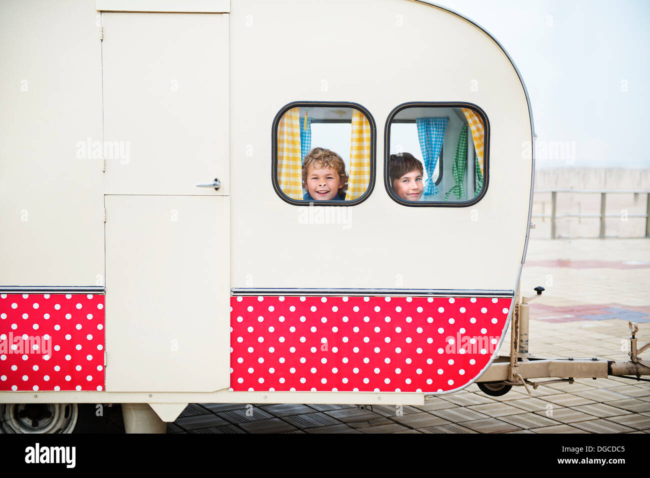 Boys looking through caravan windows, portrait Stock Photo - Alamy