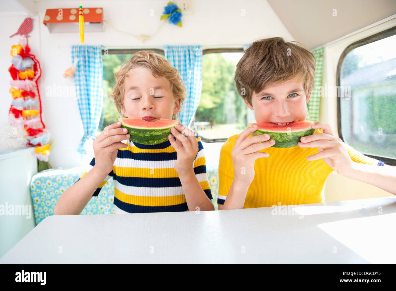 Boys eating watermelon in caravan, portrait Stock Photo - Alamy