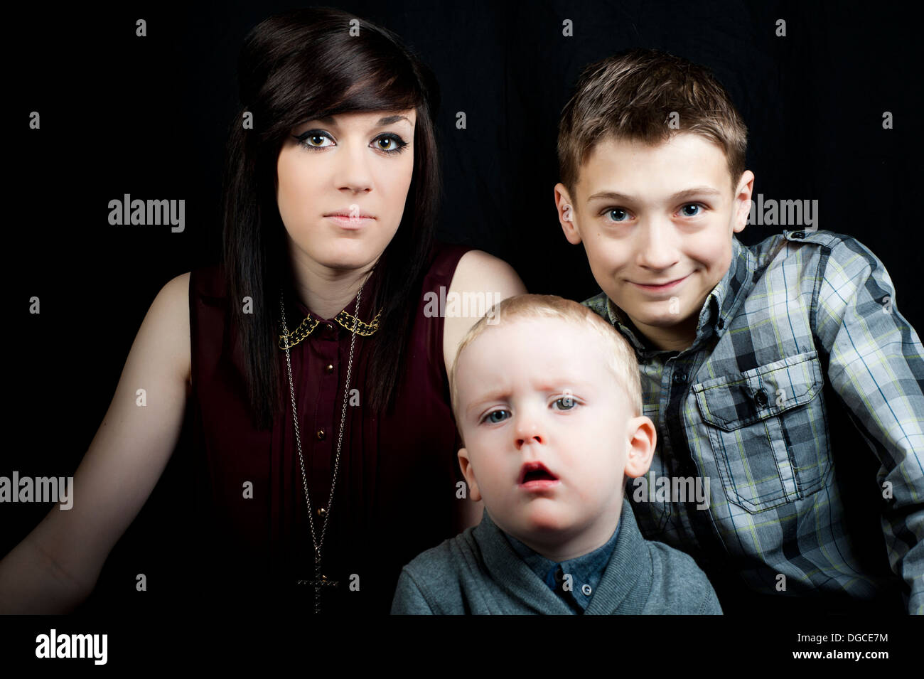teenagers and toddler looking at camera Stock Photo - Alamy