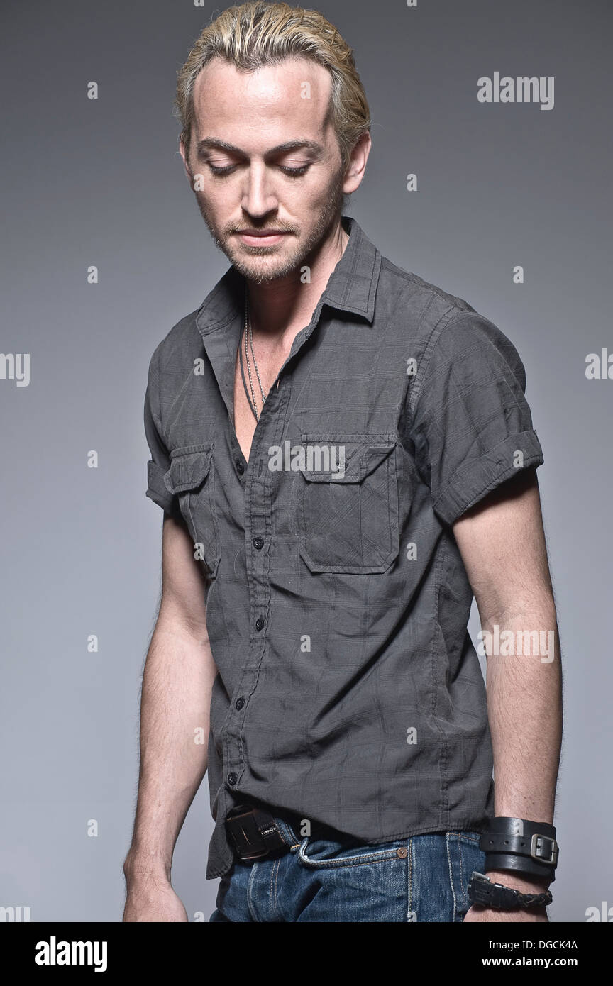 Young man looking down in studio Stock Photo - Alamy