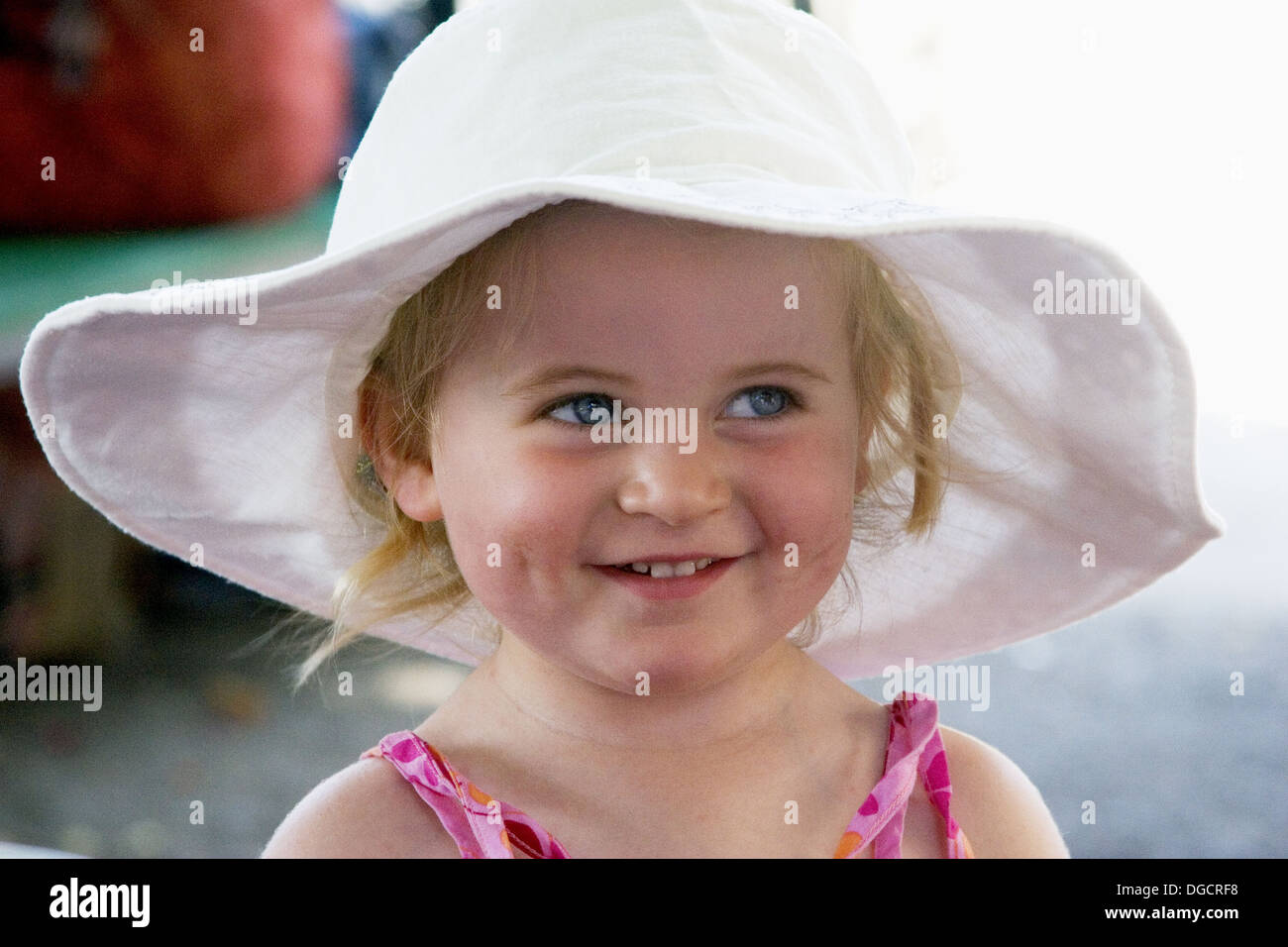 3 year old girl wearing a big sunhat amiling off camera Stock Photo - Alamy