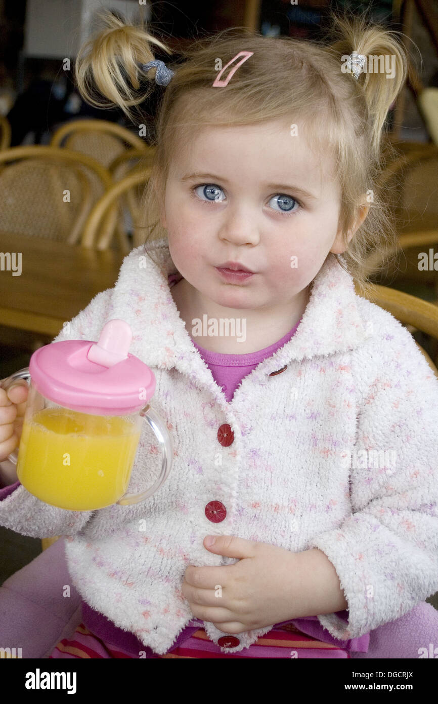 3 Year Old Girl Sitting Drinking Juice Stock Photo Alamy